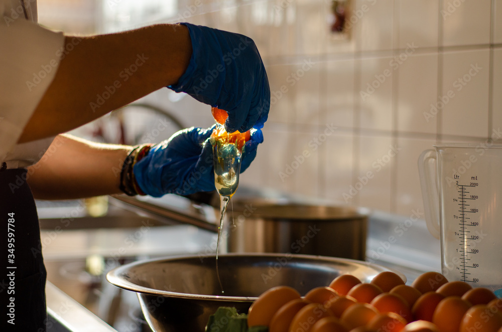 blurry chef hands crackin eggs on professional stainless steel Kitchen ...