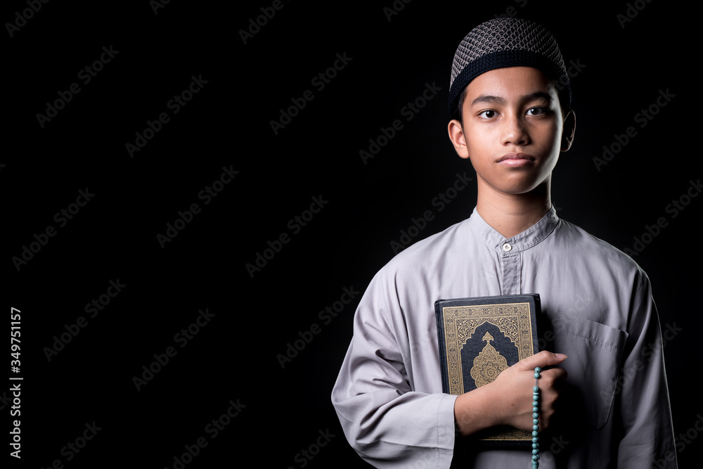 Portrait A Muslim boy in Asian Islam is standing and reading the Quran ...