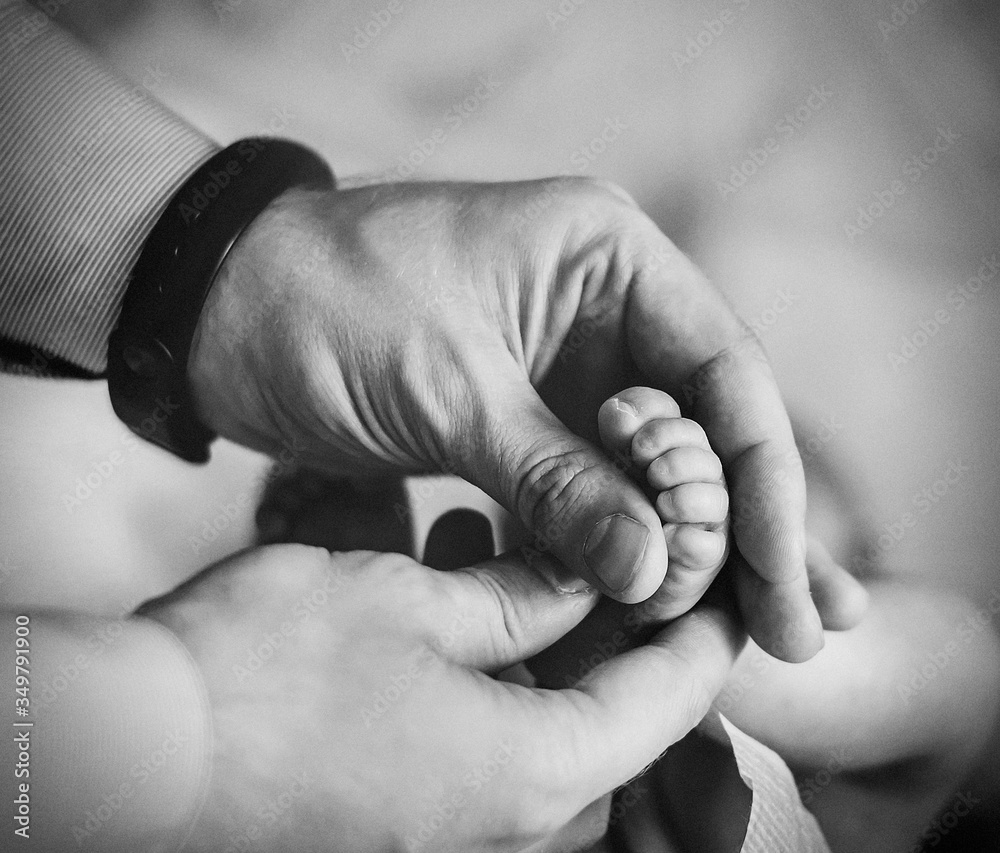 Feet of a newborn baby in the hands of parents. Happy Family concept ...