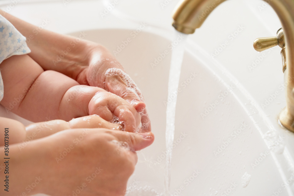 Mother and child wash their hands with soap and water. Protection from ...