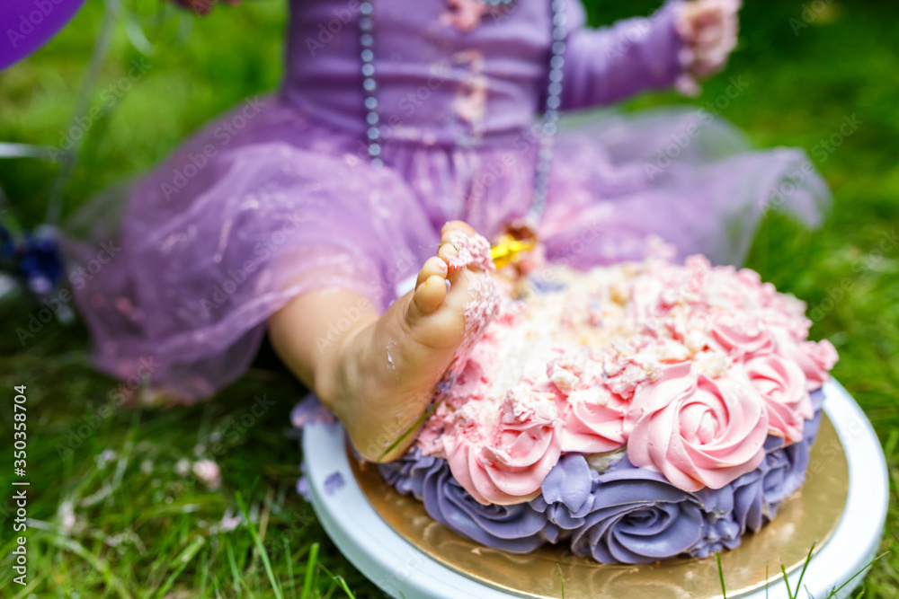 Photo Stock Close-up child breaks the cake on the green grass in the ...