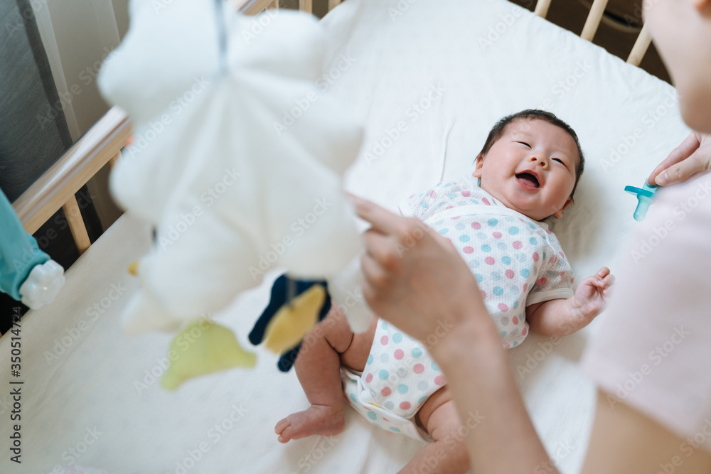 asian baby giggling while her mother playing with her with pacifier and ...