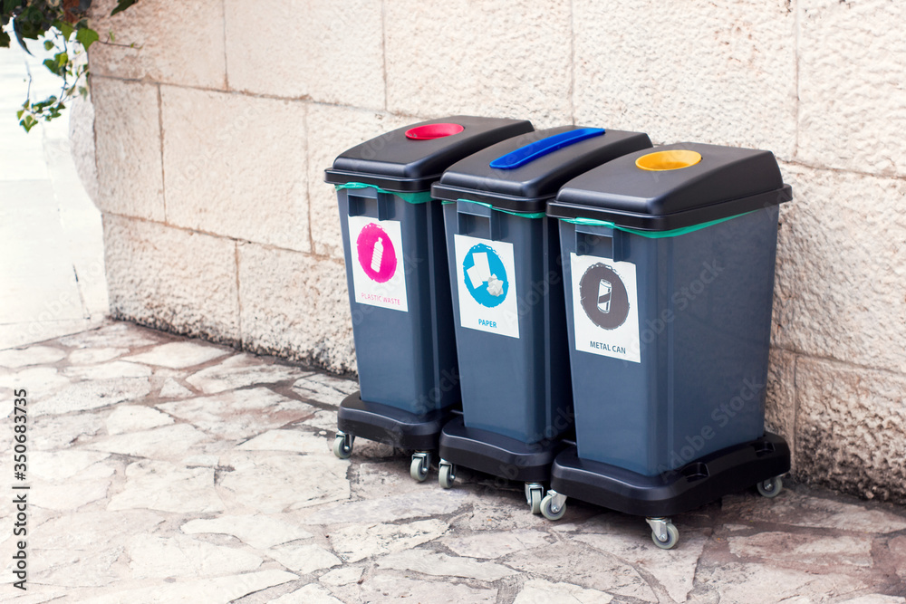 Three dumpsters with waste classification icons: plastic waste, paper ...