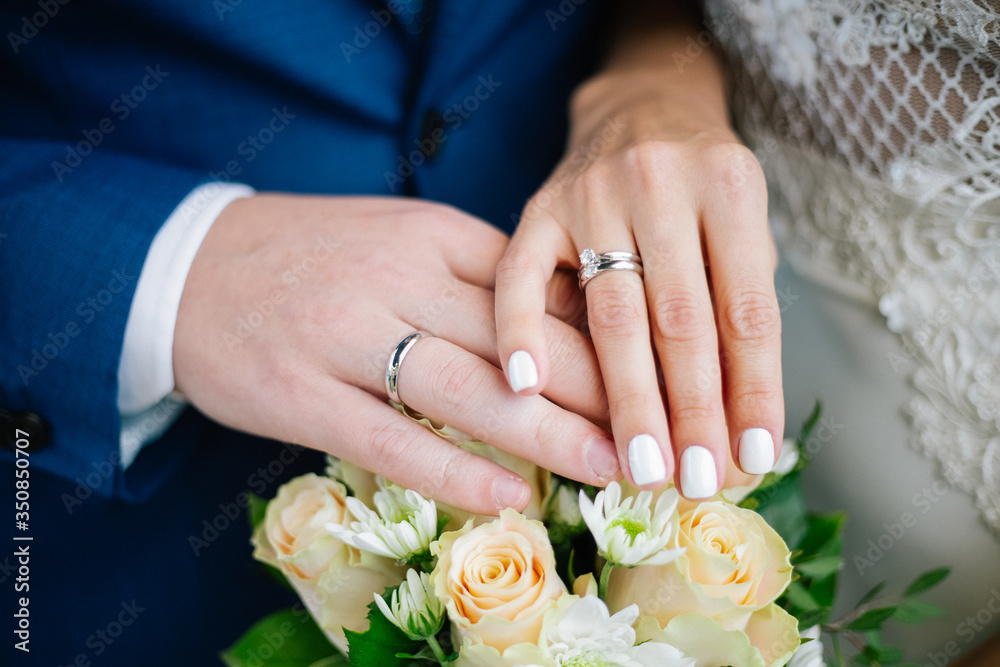 The joined hands of the bride and groom at a wedding. Wedding rings on ...