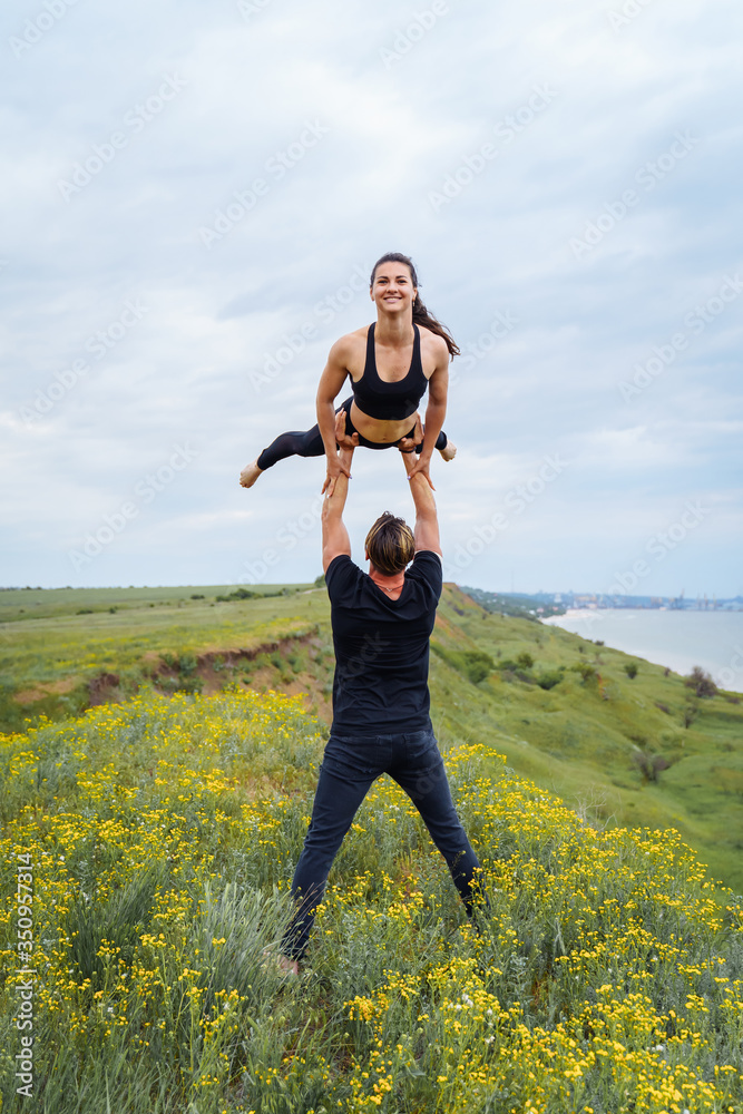 Lifestyle acroyoga and yoga poses. Pair of sportsman and sportswoman ...