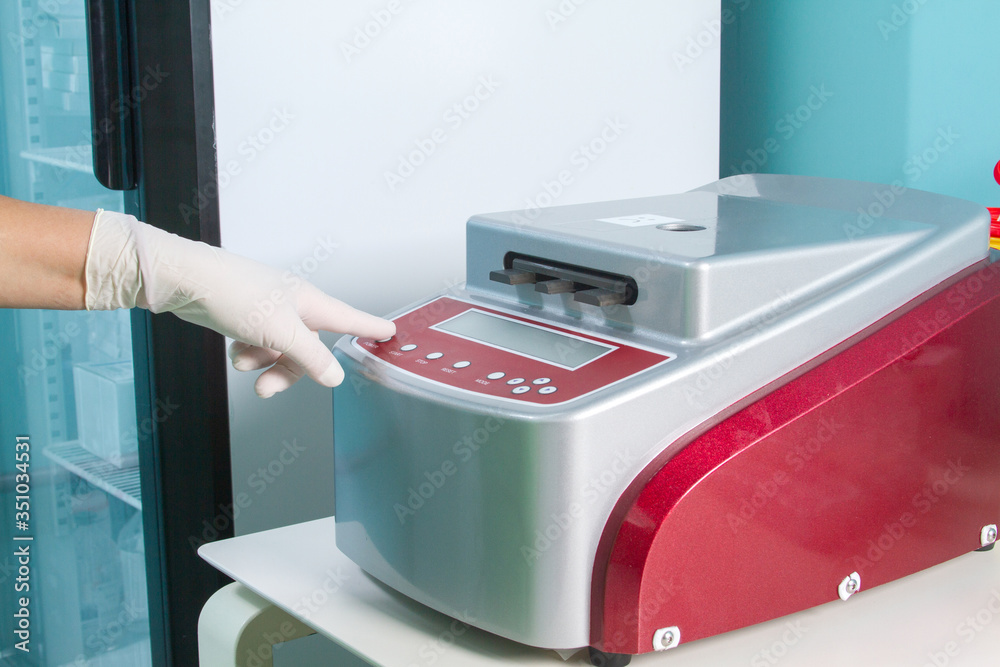 Histology test lab in hospital. Hands in gloves, tech loads slide ...