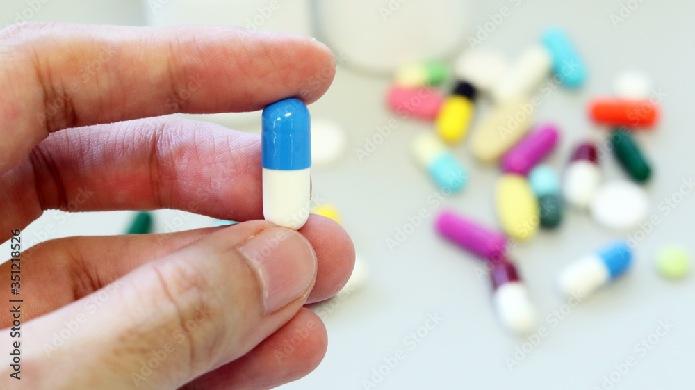 Woman hands holding blue-white capsule of Dicloxacillin, used to treat ...