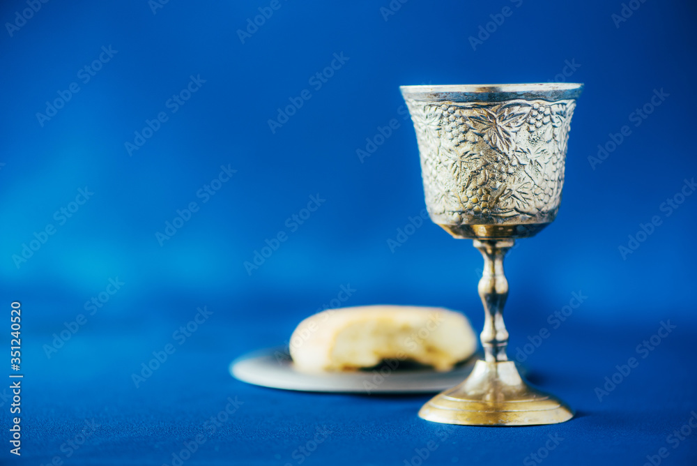 Communion still life. Unleavened bread, chalice of wine, silver kiddush ...