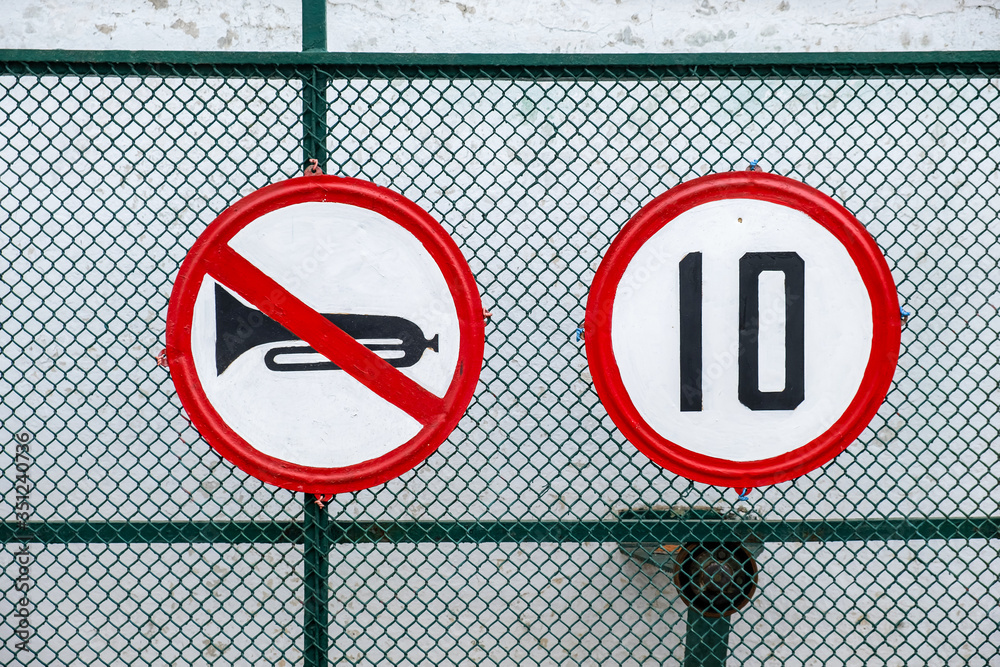 Road sign speed limit 10 km h and Beeping is prohibited on the green ...