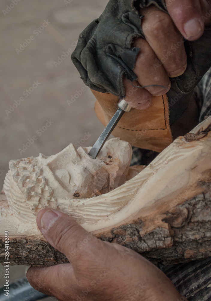 Native Indigenous craftsman working on a Wood carved sculpture of Jesus ...