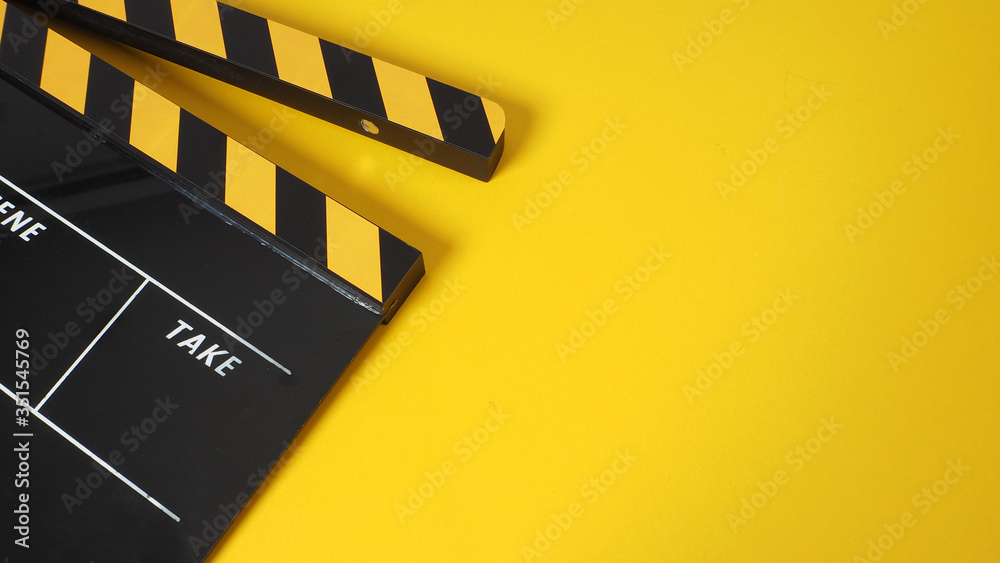 Clapper board or movie slate with black&yellow color and film roll on ...
