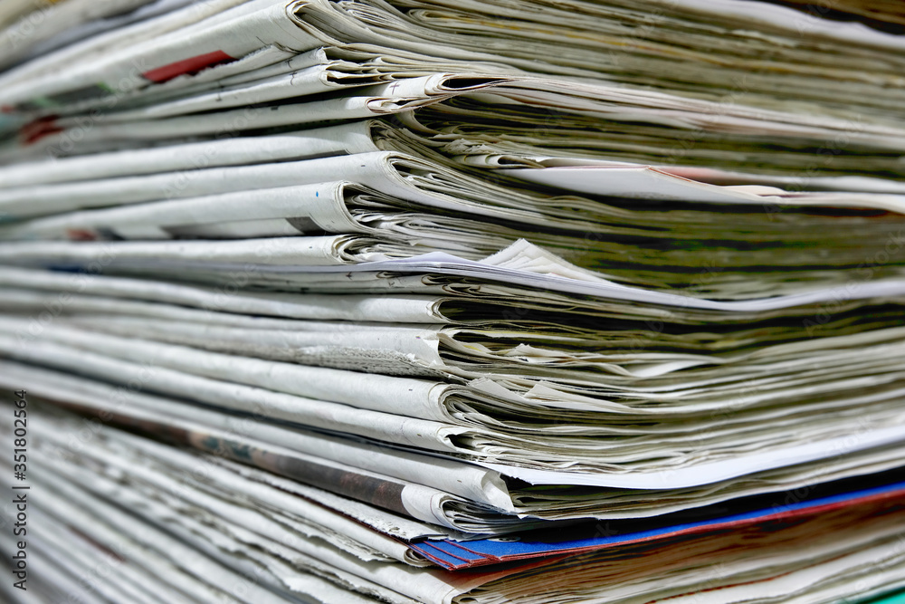 Collection of old newspaper stacked and piled up, ready for pickup and ...