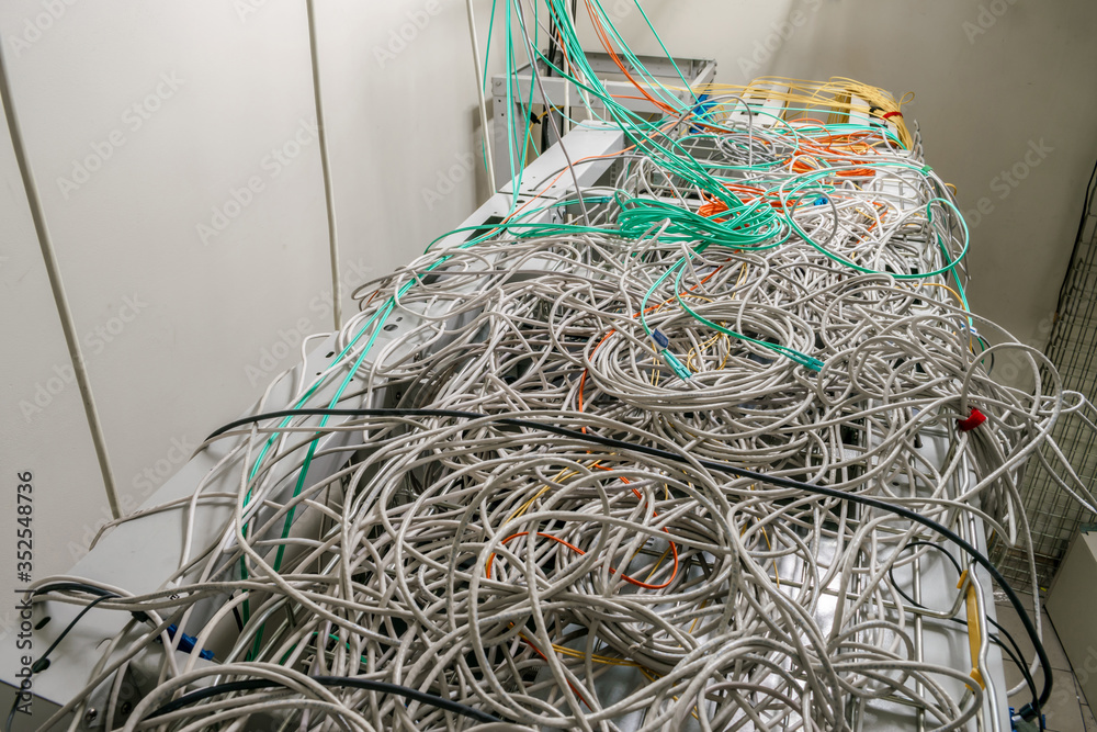 Many tangled wires are on top of the server racks of the data center ...