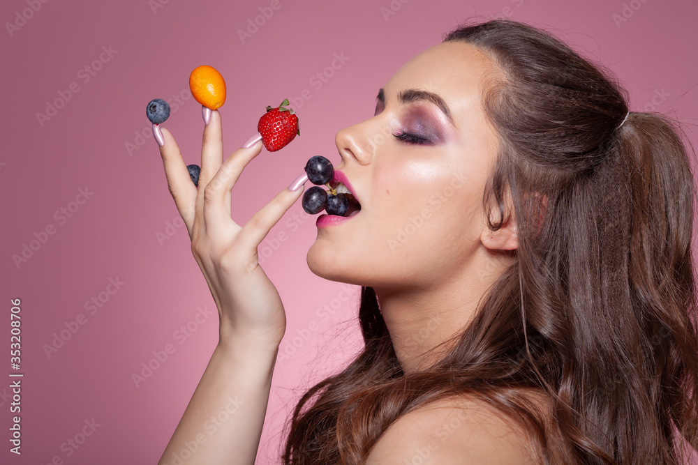 Young sexy woman eating fruits from her fingers Stock Photo | Adobe Stock