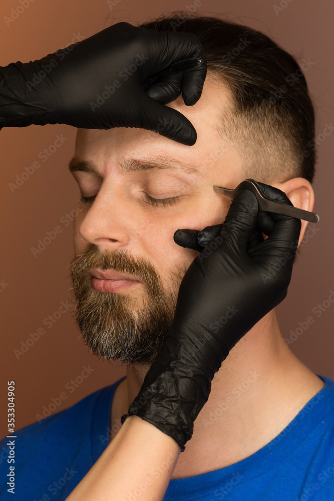 Professional barber doing threading procedure and correcting shape of ...