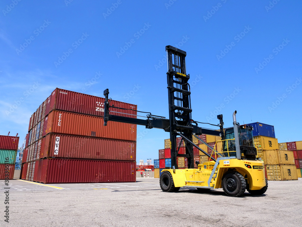 Hyster container handler lifting a Red Hamburg Sud Shipping container ...