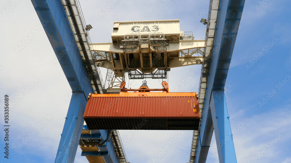 Transtainer crane moving a Shipping Container to a storage platform ...