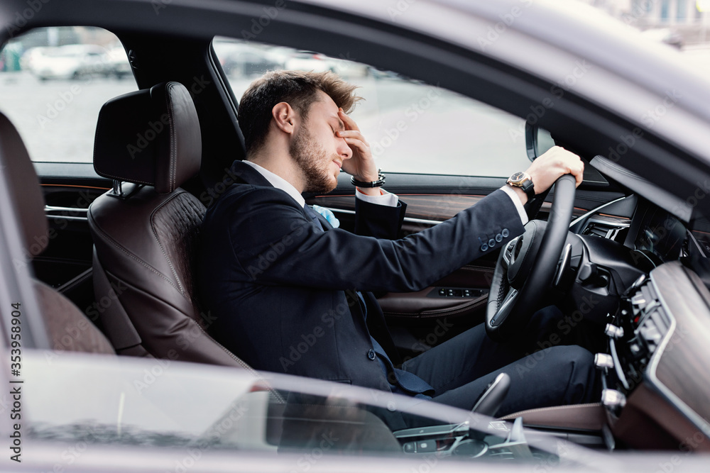 Sad businessman driving alone in his new car Stock Photo | Adobe Stock