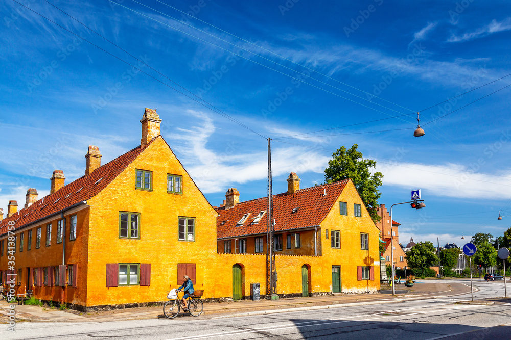Stock-Foto „Old yellow houses of Nyboder district and woman on a ...