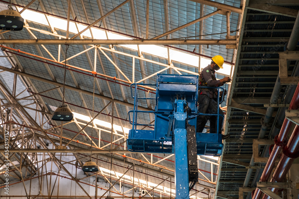 Technician use boom lift Install Electrical system. In the industrial ...