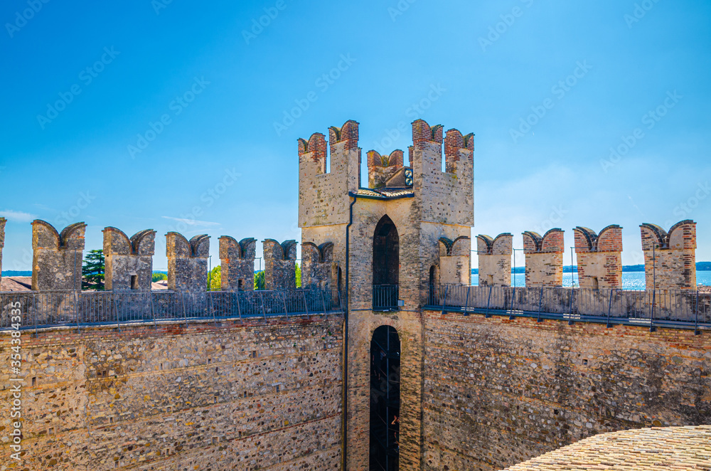 Tower and stone defense wall with swallowtail merlons of Scaligero ...