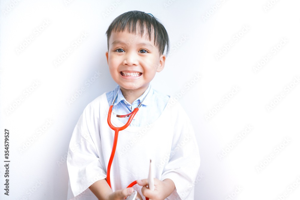 portrait of small kid wearing doctor gown uniform standing and smiling ...