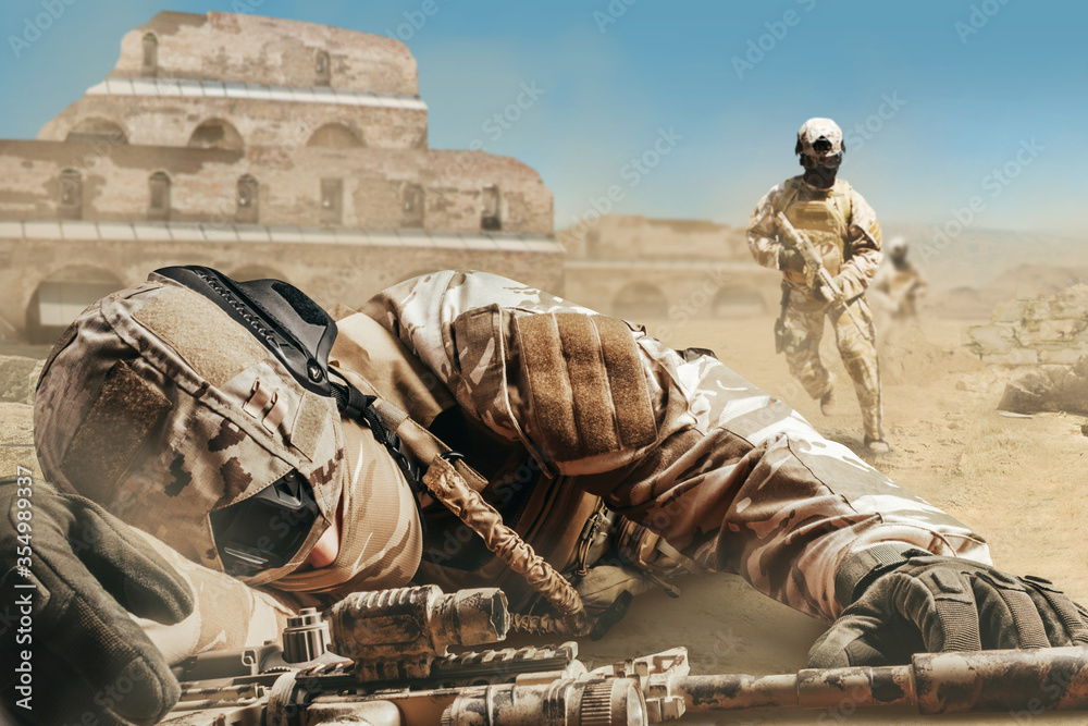 Fully equipped fallen soldier laying on desert city battlefield and ...