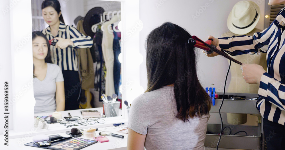 skilled young asian chinese stylist wrap curling hair in dressing room ...