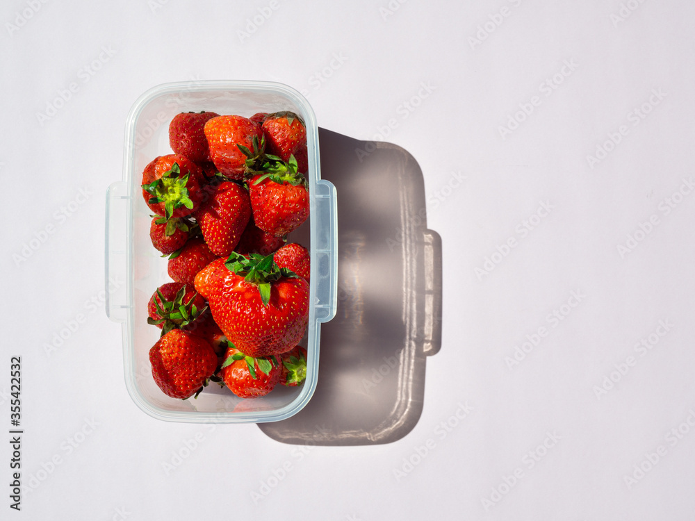 berry storage: strawberries in plastic container on white background ...