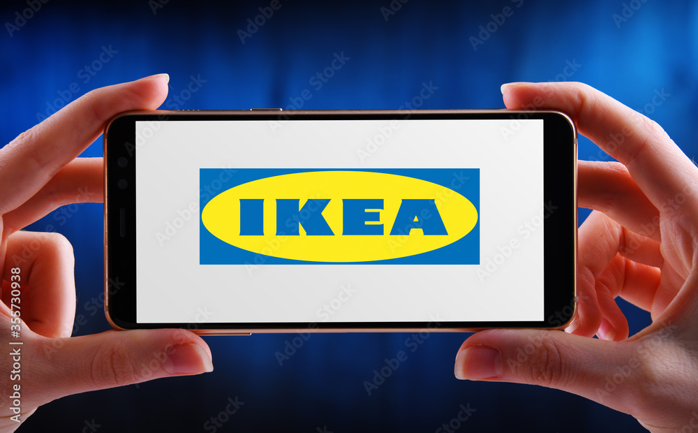 Hands holding smartphone displaying logo of IKEA Stock Photo | Adobe Stock