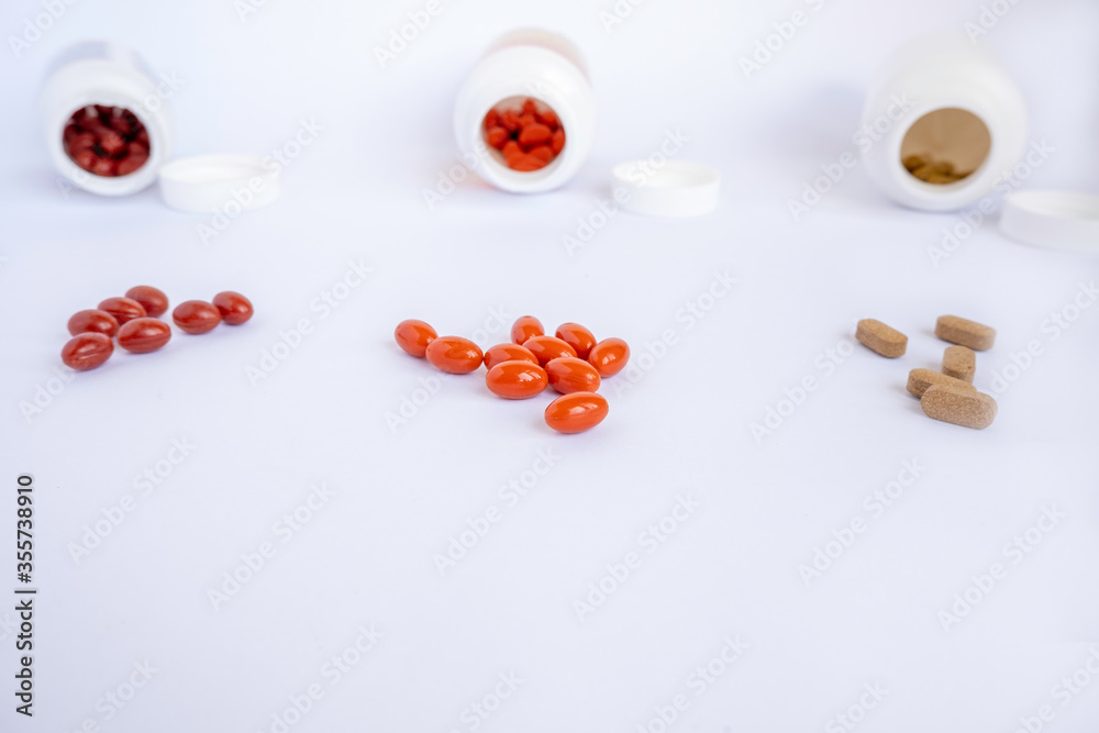 Photo Stock Three handfuls of red capsules and herbal tablets next to ...
