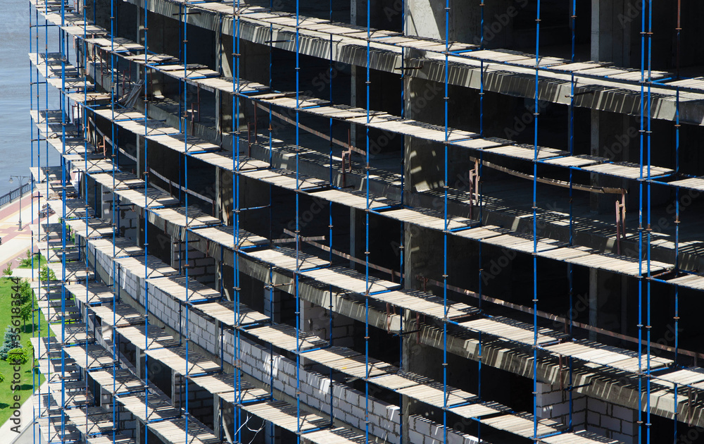 Skeleton of a monolithic multi-storey building; with scaffolding on the ...