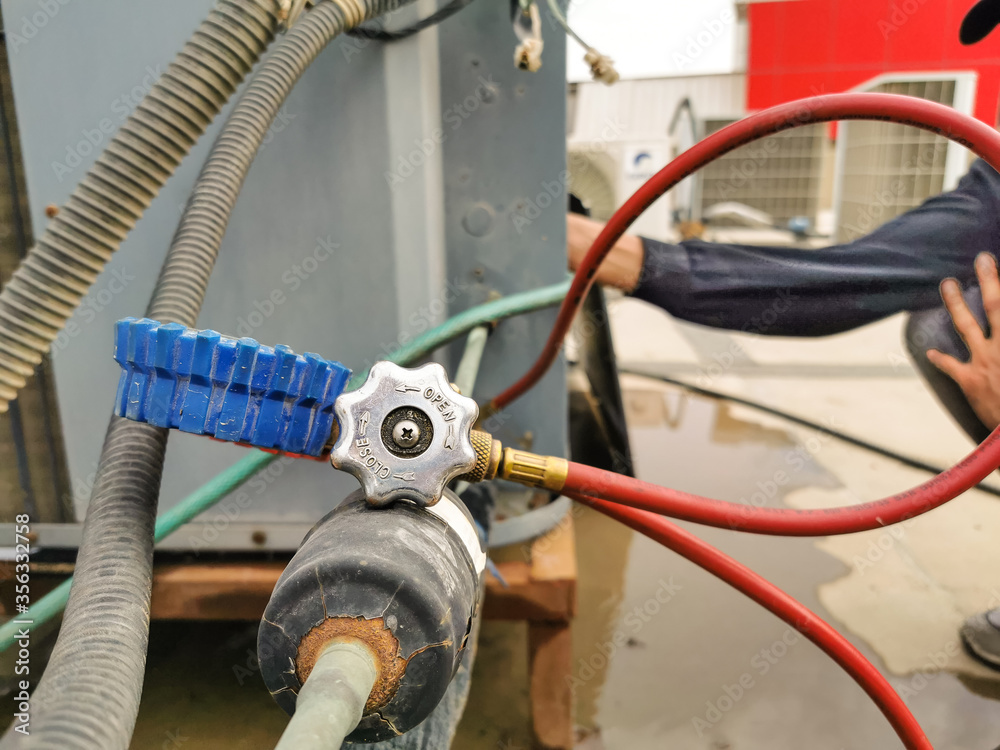 gas is being refiling into the heavy ac compressor of central air ...