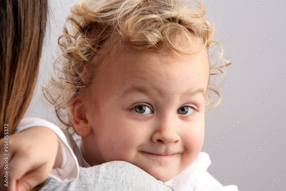 Happy cheerful child on mothers hands. Warm hug from caring people ...