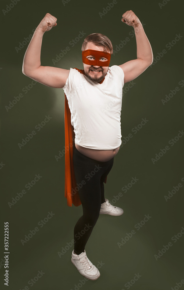 Strong superhero expressing power. Man in white t-shirt, red mask and ...