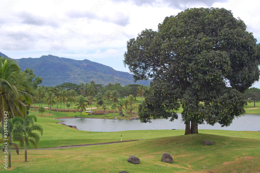 Golf course with trees, mountain, and lake at Mount Malarayat in Lipa ...