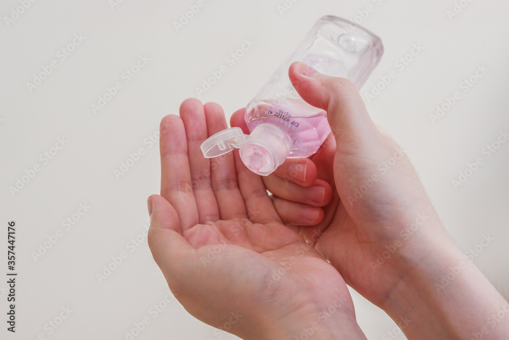 Foto de Stock Light-skinned Asian woman pouring a hand sanitizer gel ...