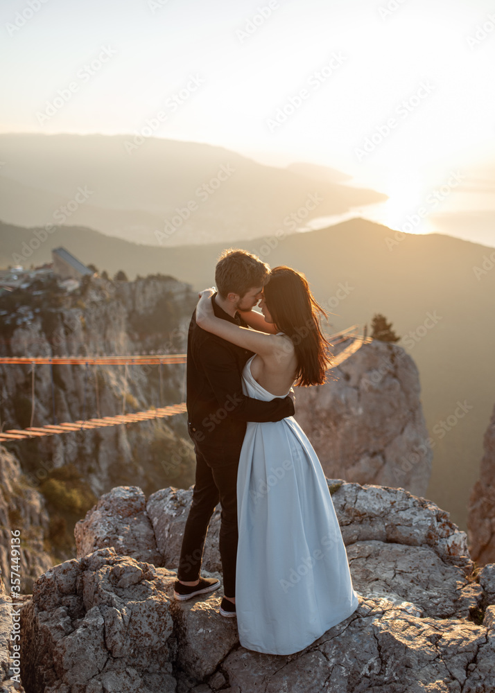 Beautiful lovers cuddle to each other on the edge of an impressive ...