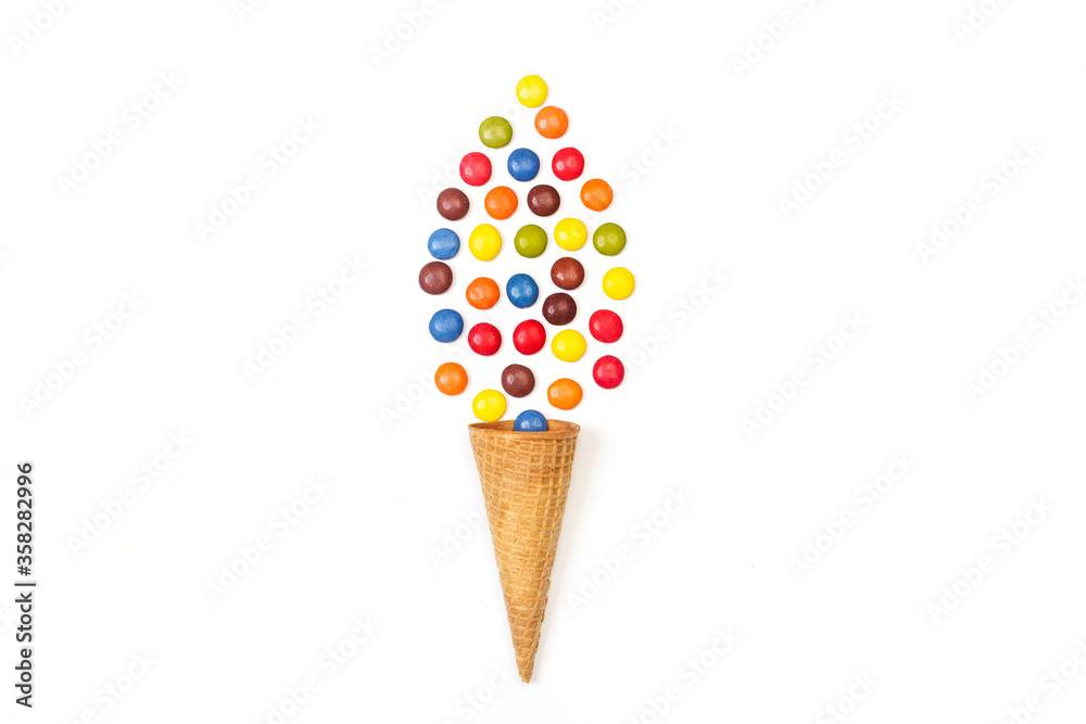 Grageas de chocolate de colores junto a un cono de oblea de helado ...
