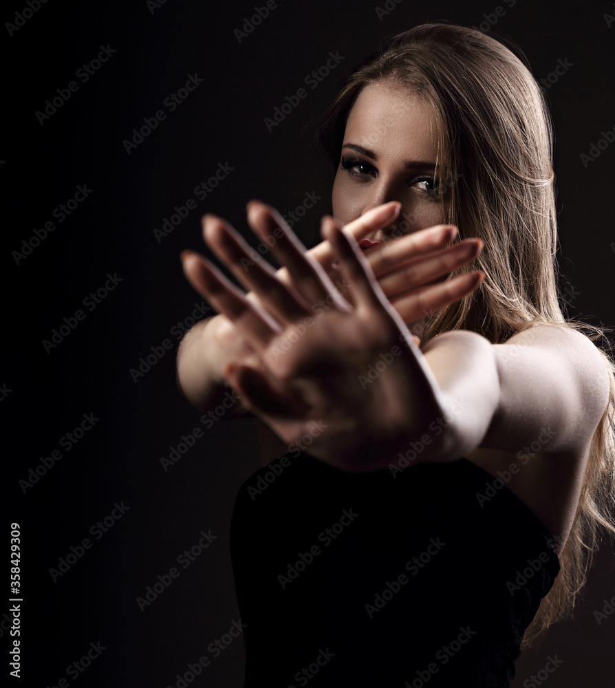 Angry young female blond model showing the hands and signaling to stop ...