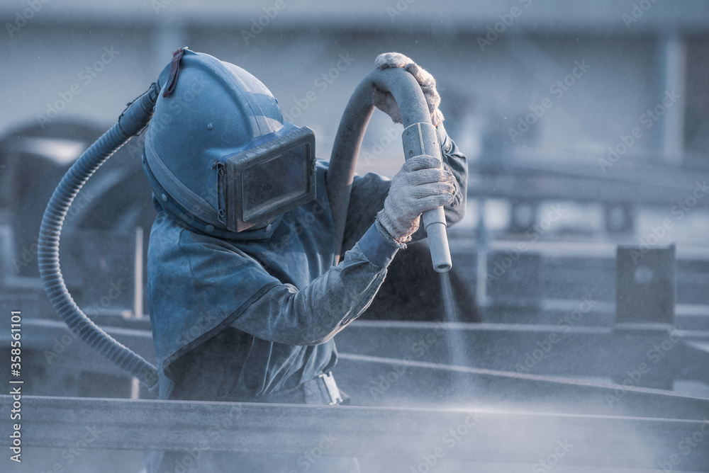 Sand blasting process, Industial worker using sand blasting process ...