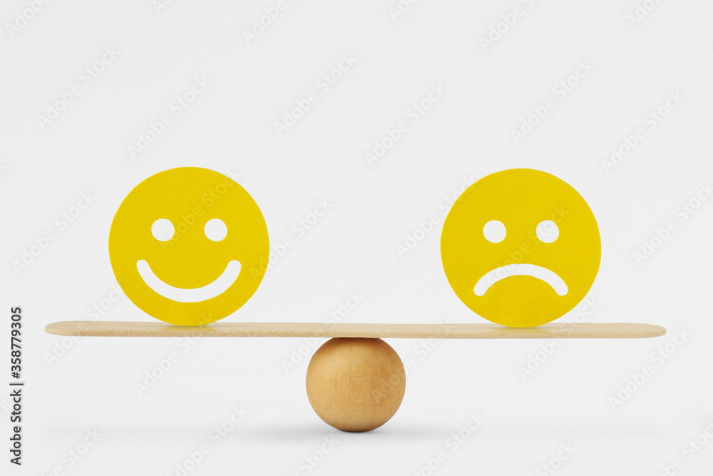 Smiley face and sad face on scale - Concept of balance between ...