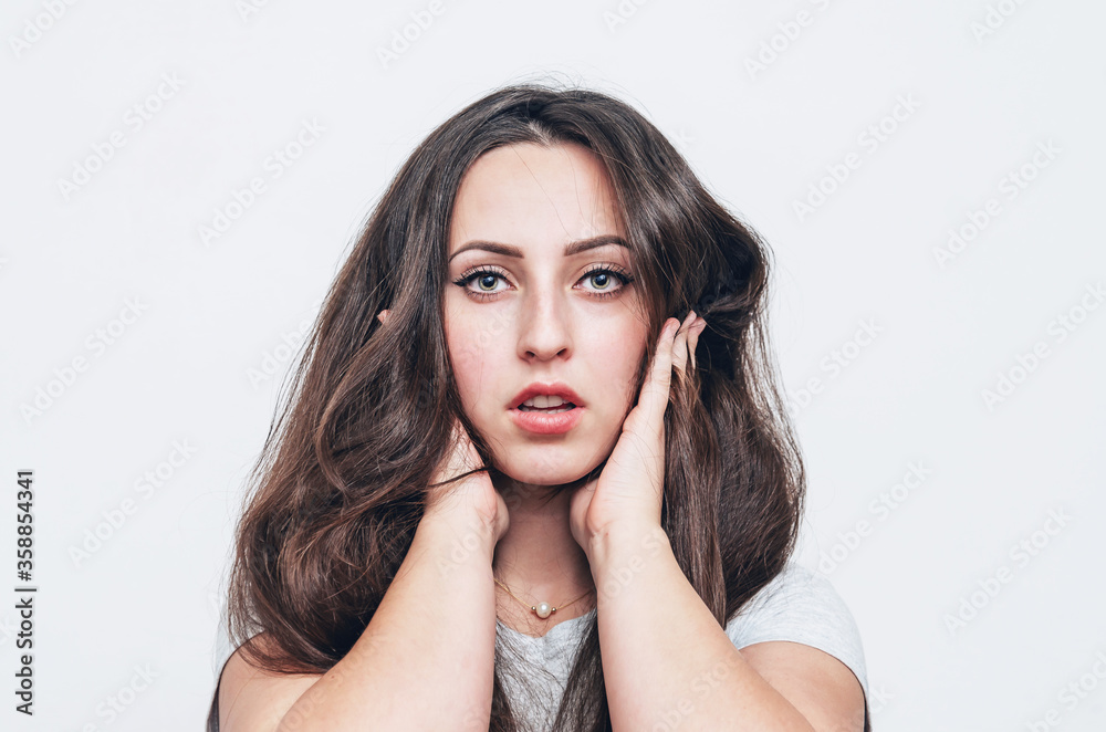 Portrait of a girl with long dark hair ruffled hair on her head, raised ...