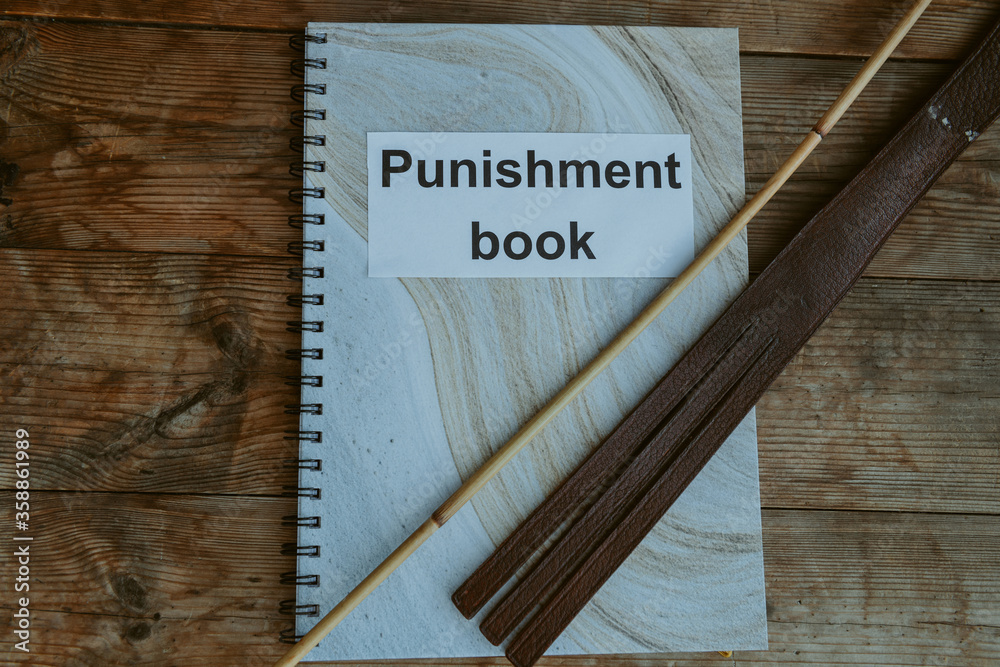 Punishment book. Leather tawse and cane for spanking on headmaster's or ...