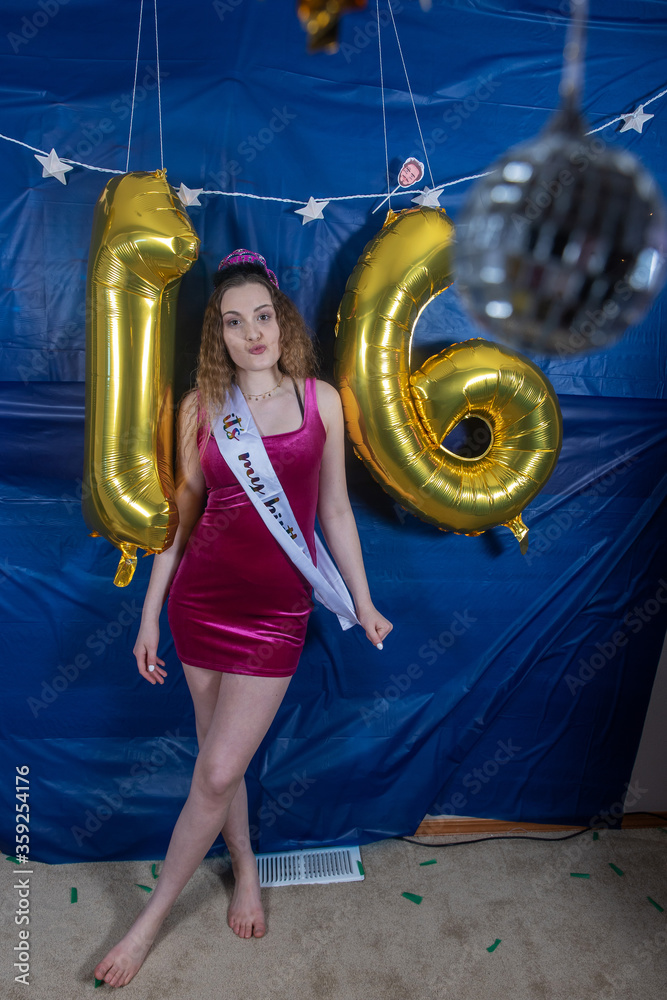 Sixteen year old girl wearing a tiara and sash celebrates her birthday ...