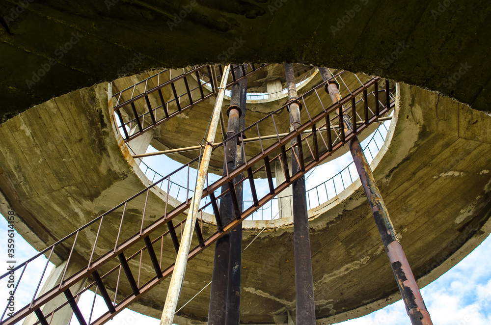 Abandoned pumping station. Water tower of concrete and wood, metal ...