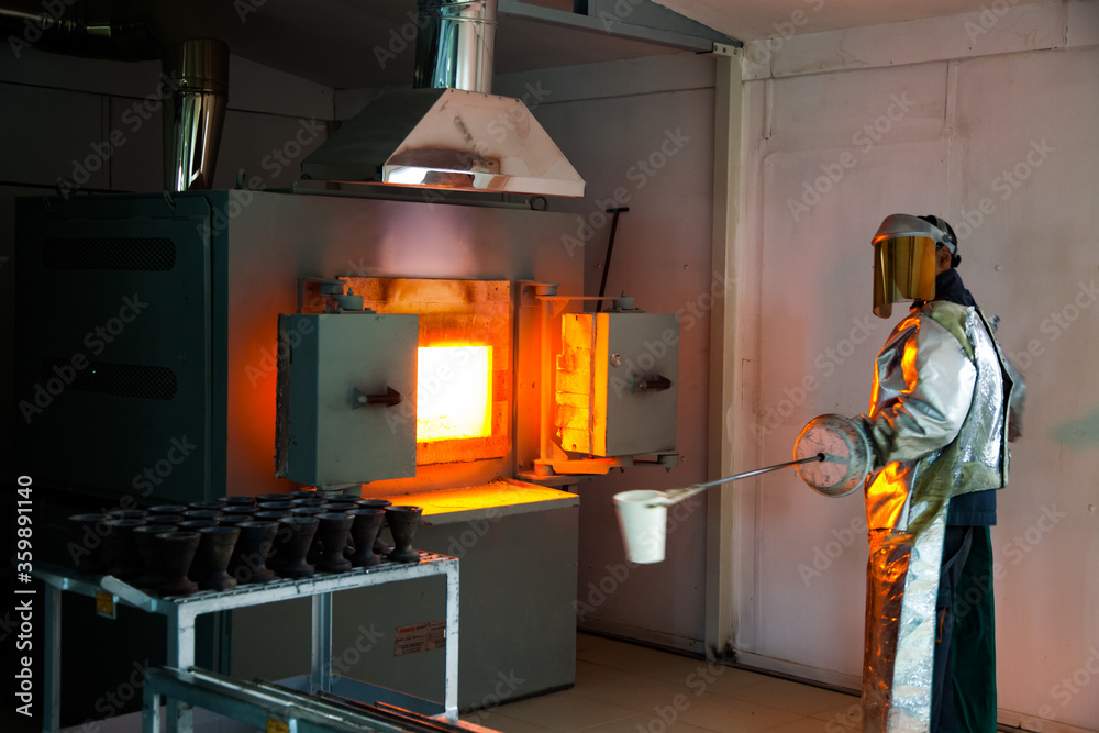 Gold melting. Metallurgy lab of golden manufacturing plant. Taking ...