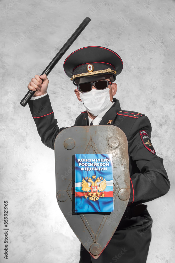 Russian police officer in a white mask holds a steel knight's shield ...
