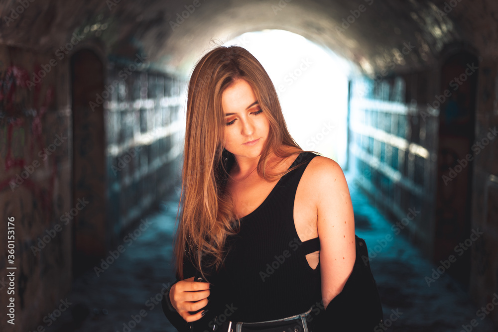Beautiful young girl posing inside a tunnel in an old fortificacion ...