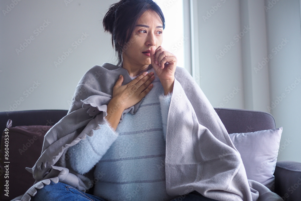 Asian women have a cough and angina. Sick woman lying on the sofa ...